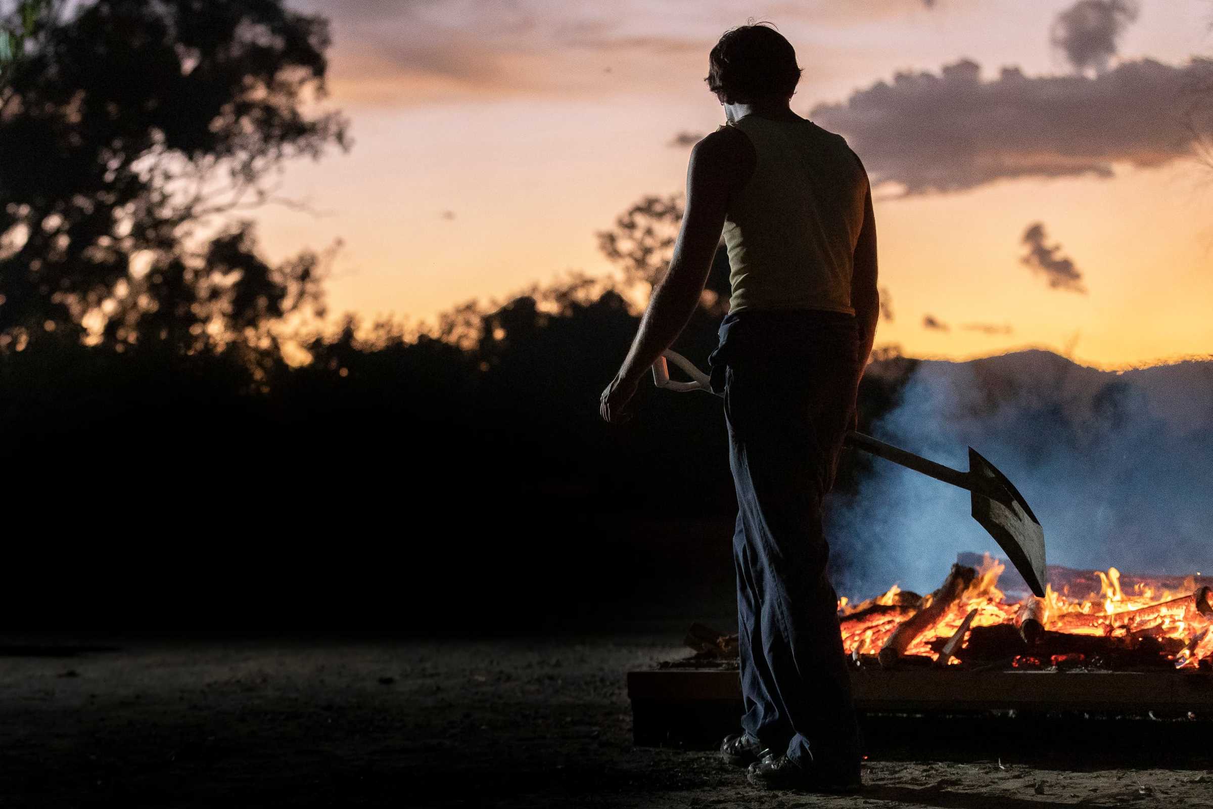 The artist Joel Spring stands with his back to the camera looking at a ...